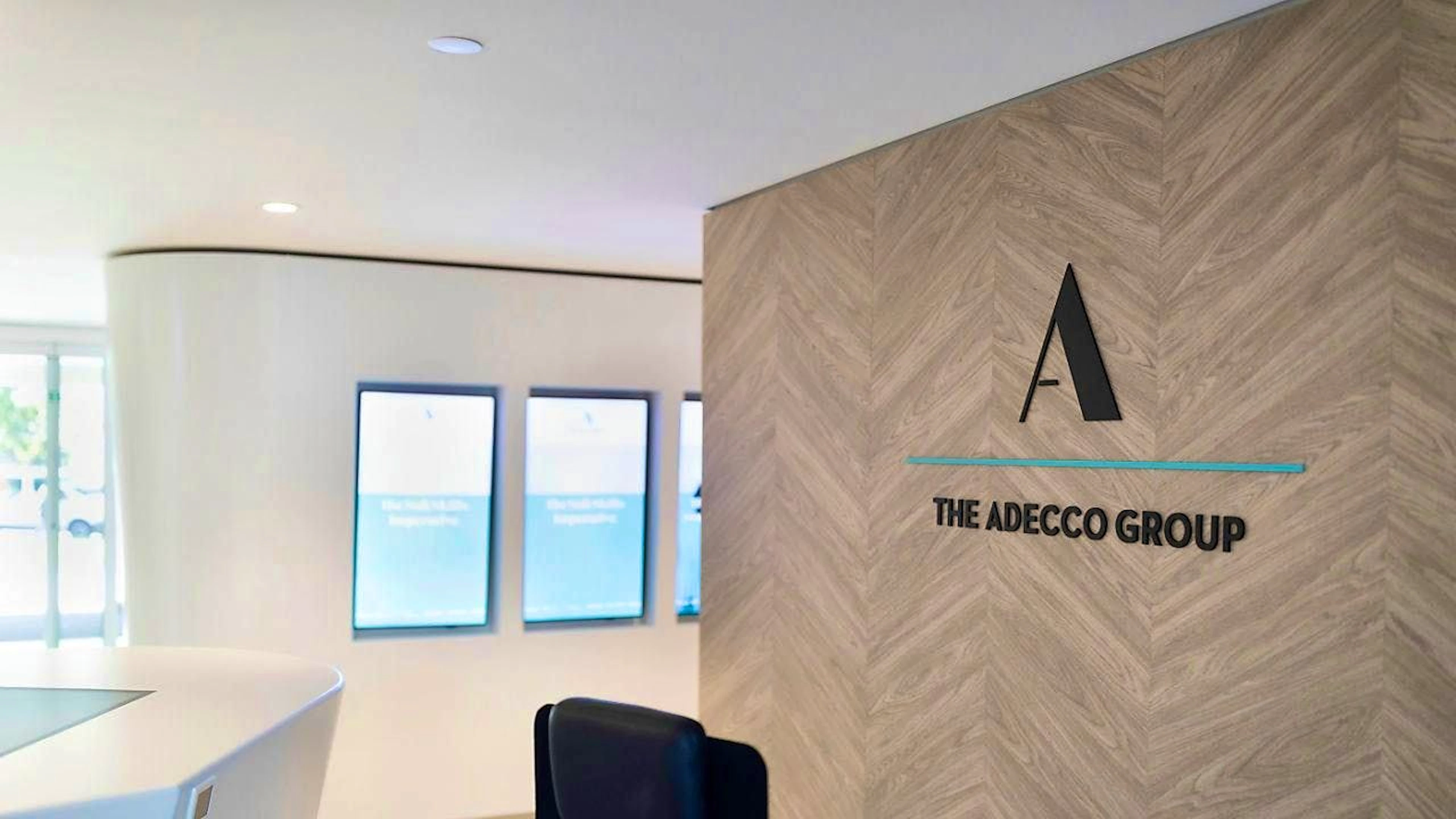 Adecco posts lower sales and cuts dividend