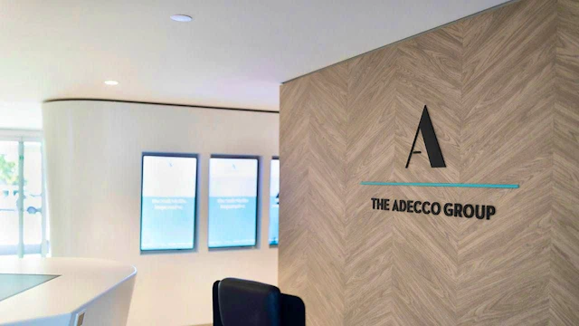 Adecco posts lower sales and cuts dividend