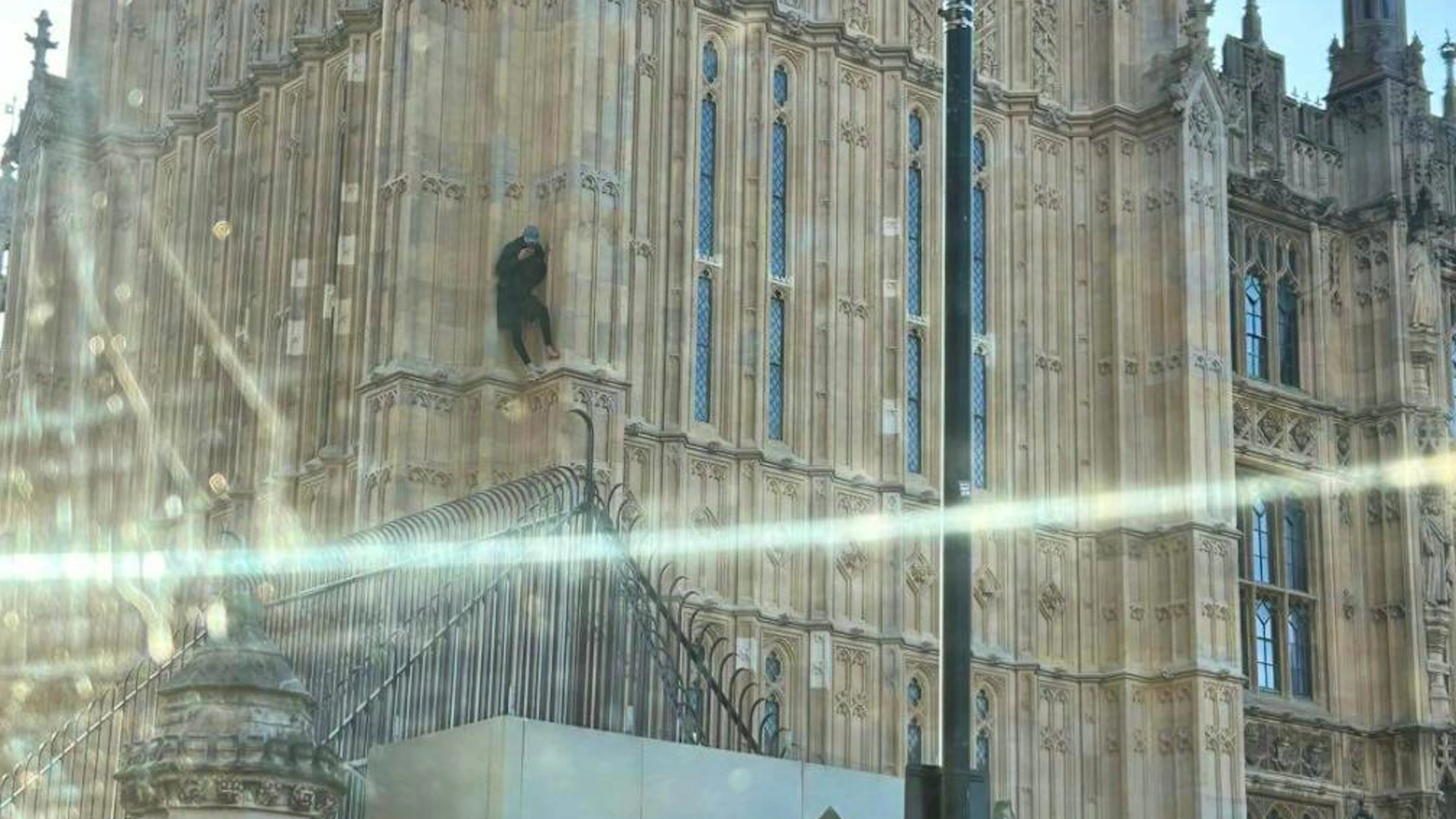Mann klettert barfuss Big Ben hoch